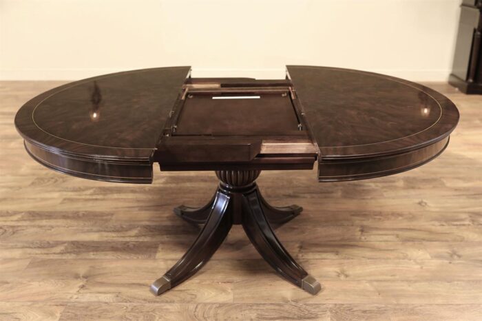 Round to oval dining table in dark walnut finish, with self-storing ...