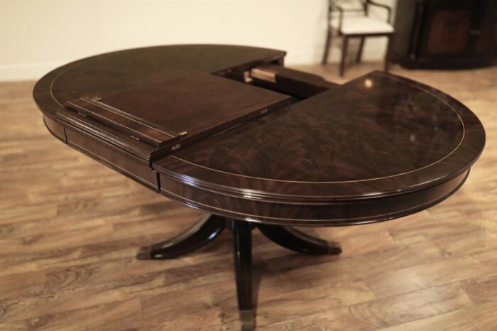 Round to oval dining table in dark walnut finish, with self-storing ...