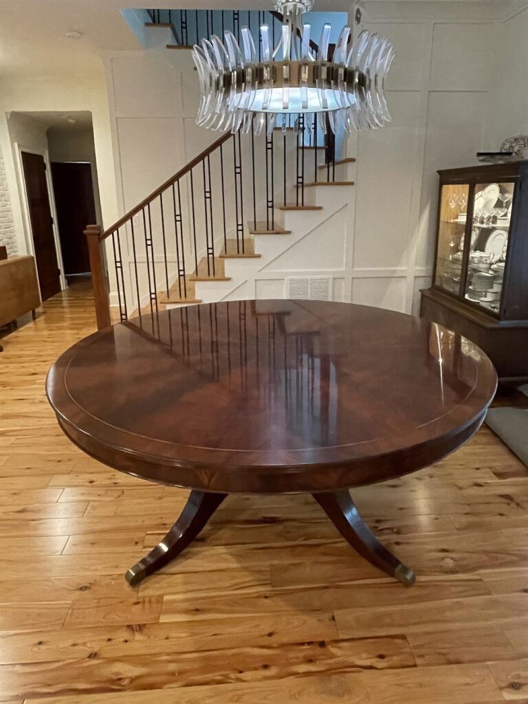 Custom 72-inch mahogany pedestal table with self-storing leaf.
